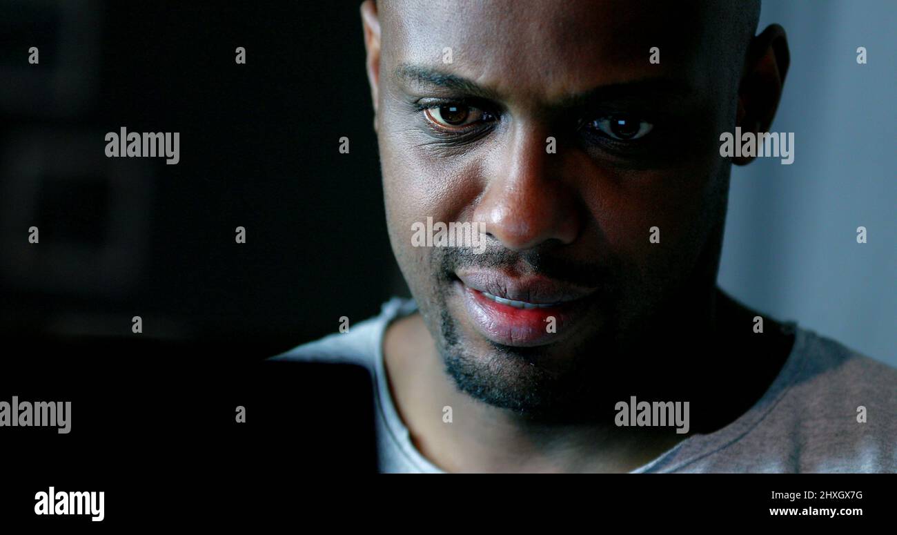 Close-up black man face looking at computer screen at night Stock Photo ...