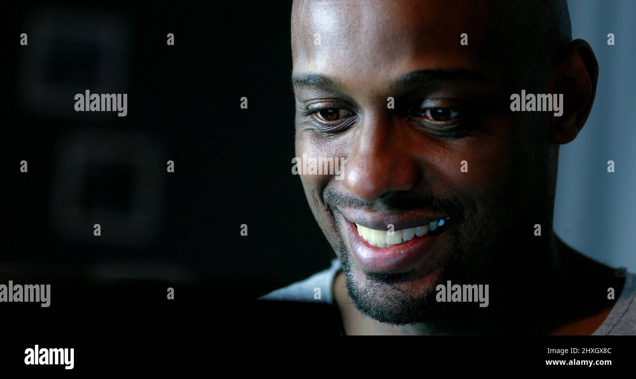 Close-up black man face looking at computer screen at night Stock Photo ...