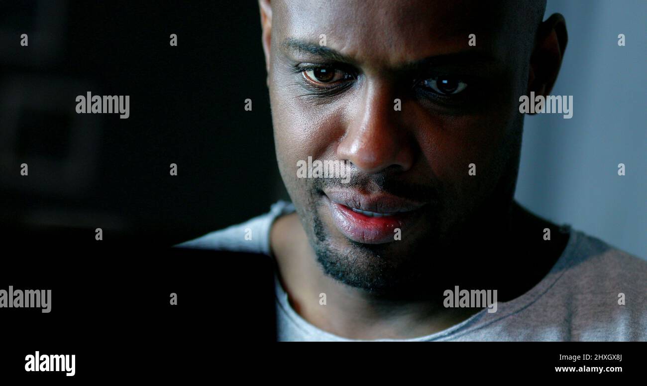 Close-up black man face looking at computer screen at night Stock Photo ...