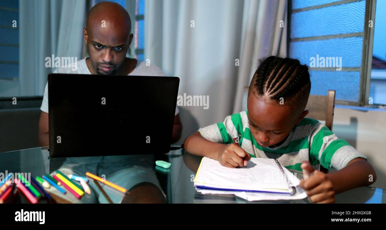 Father multi-tasking using computer laptop at home. Candid authentic ...
