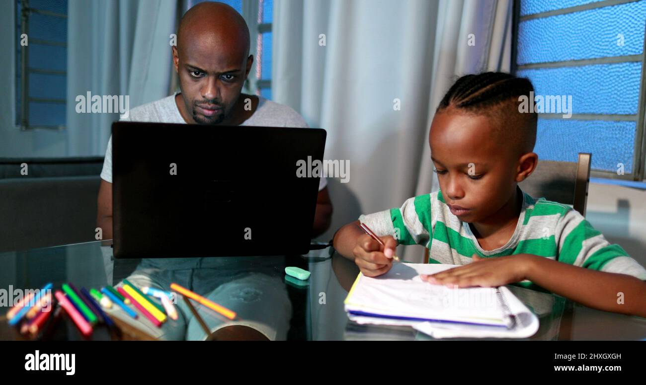 Father multi-tasking using computer laptop at home. Candid authentic ...
