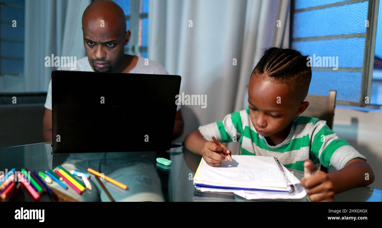 Father multi-tasking using computer laptop at home. Candid authentic ...