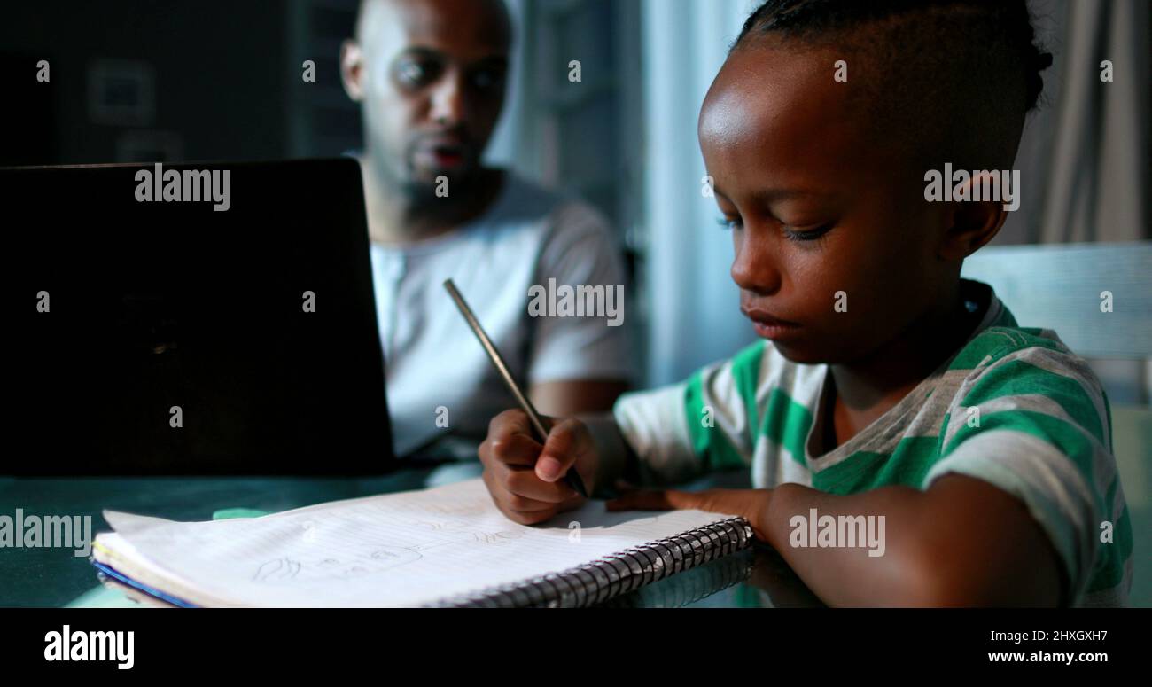 Father multi-tasking using computer laptop at home. Candid authentic ...