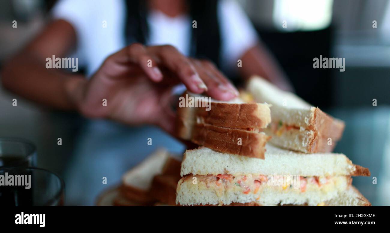 Girl grabbing sandwich from plate. Teen woman eating calorich food carb ...