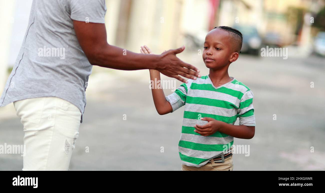 Little boy doing handshake with father. African ethnicity Stock Photo ...