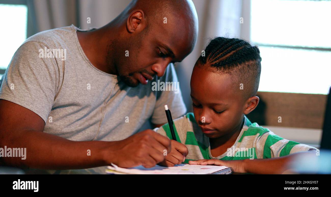 Little boy doing homework at home, African father helping son with ...