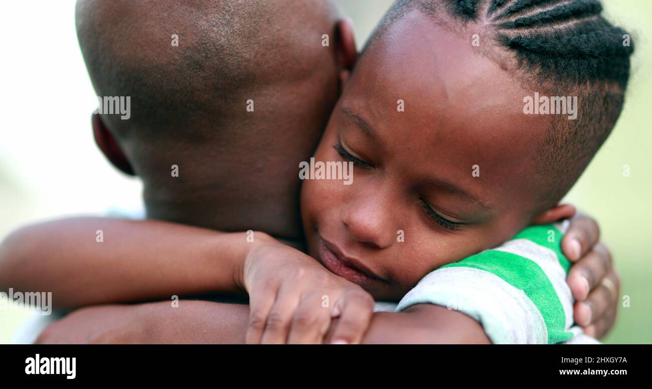 Son hugging father. African kid embracing dad, candid authentic love ...