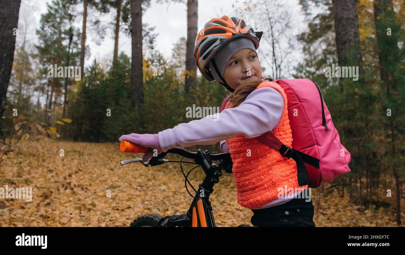 One caucasian children walk with bike in autumn park. Little girl ...