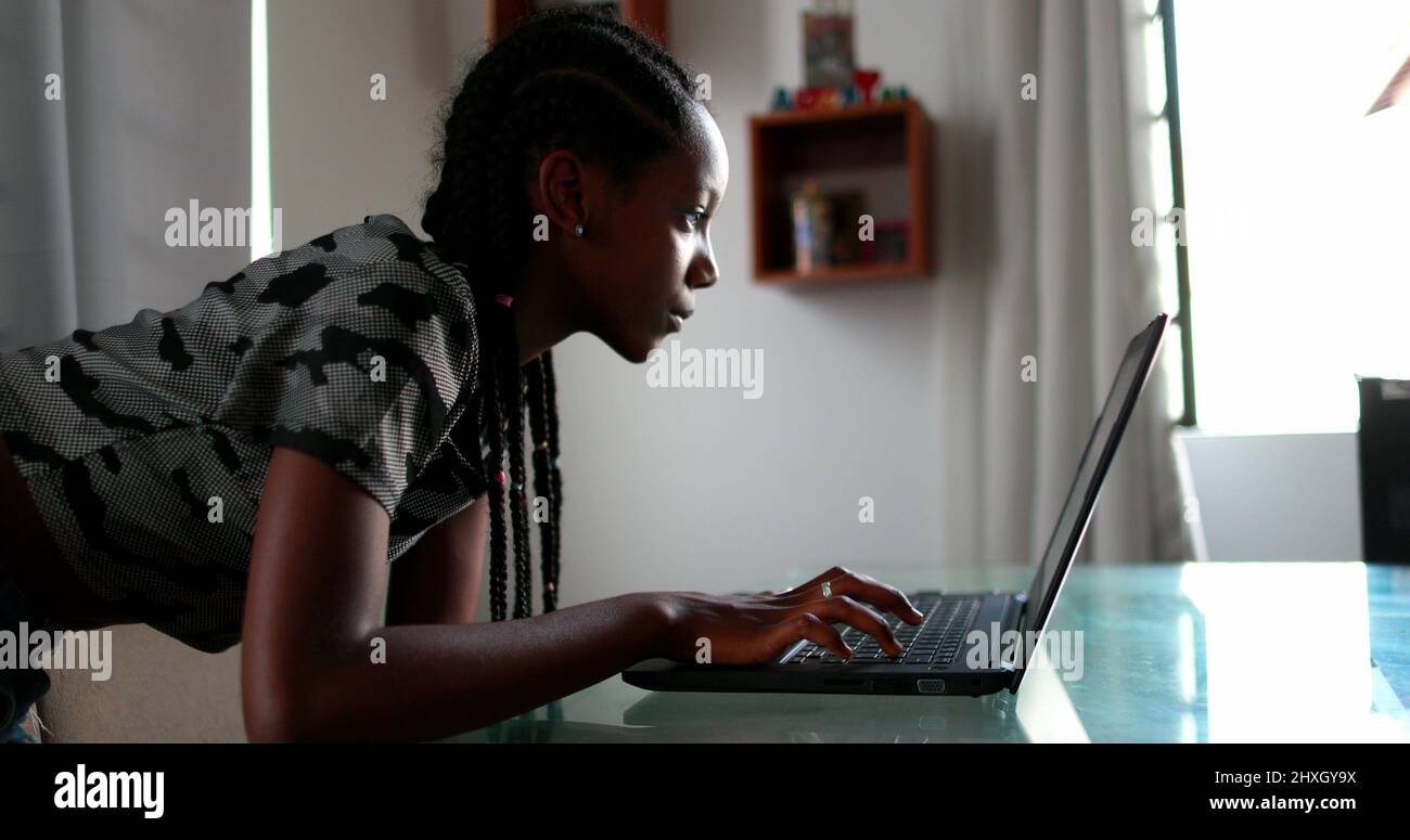 Teen black girl using latop. African american teenager browsing ...