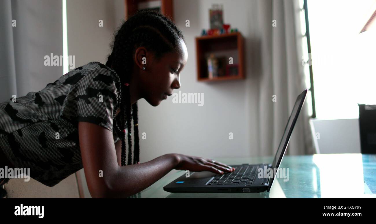 Teen black girl using latop. African american teenager browsing ...