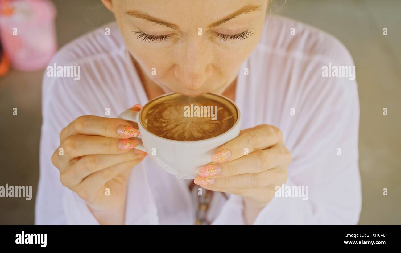 Woman drinking tasty beverages coffee Cappuccino Latte Art. Traveler ...