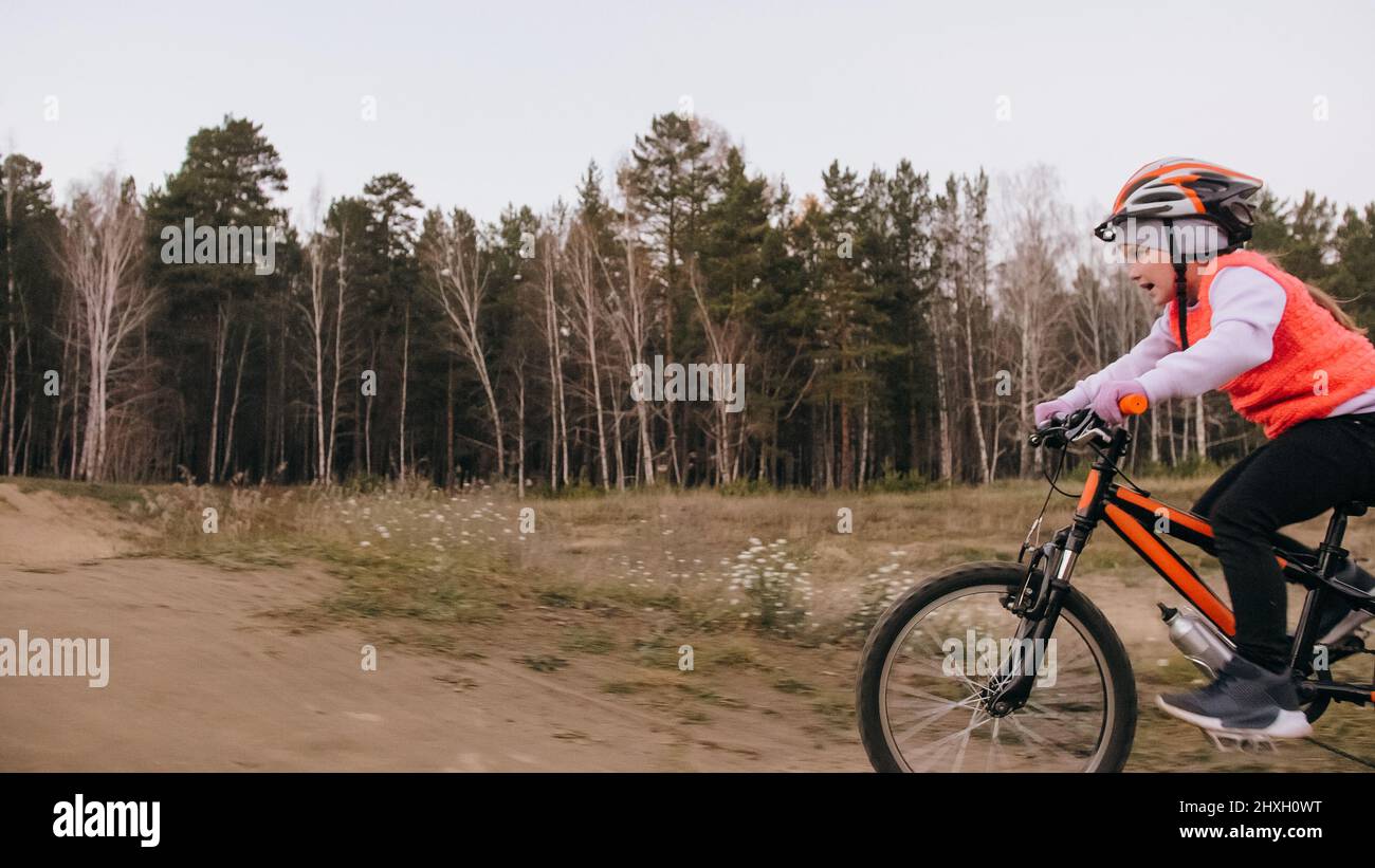 One caucasian children rides bike road track in dirt park. Girl riding ...