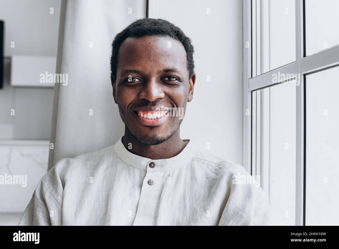 Portrait of handsome positive young African-American man in white shirt ...