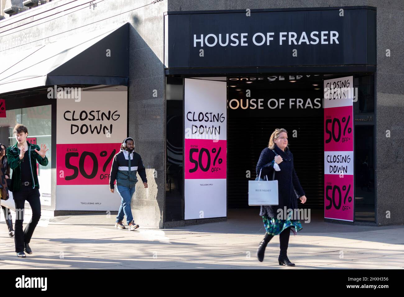 People walk past House of Fraser, with signs that say ‘Closing down. 50 ...