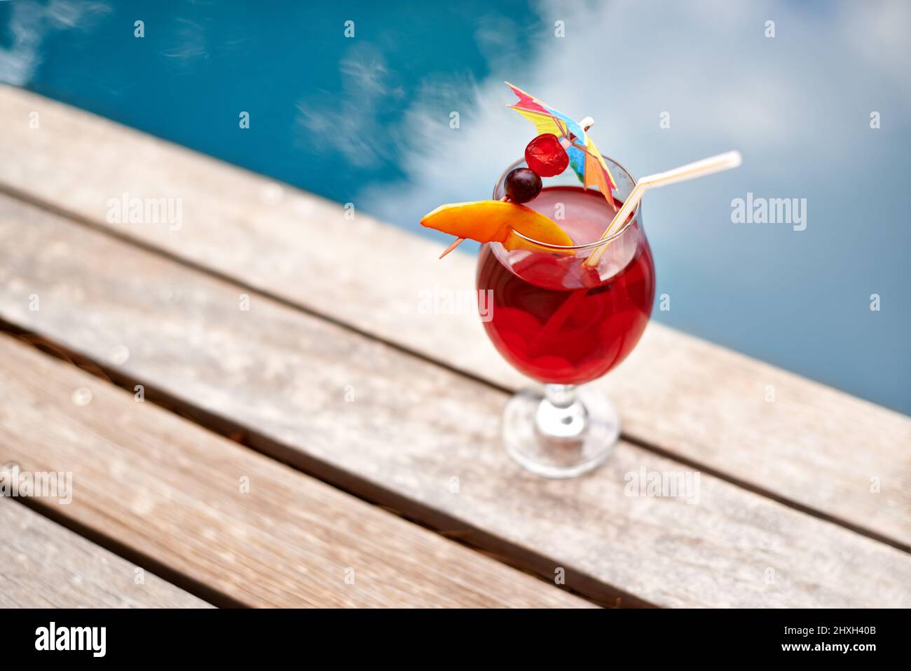 Summertime refreshment. A fruity cocktail on a wooden deck next to an ...