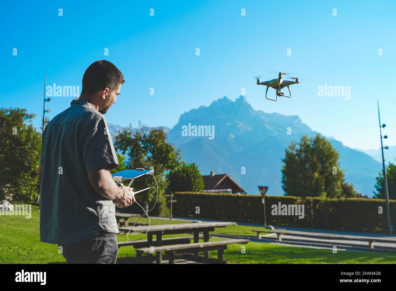 Young man flying drone on amazing mountain landscape. Man operating a ...