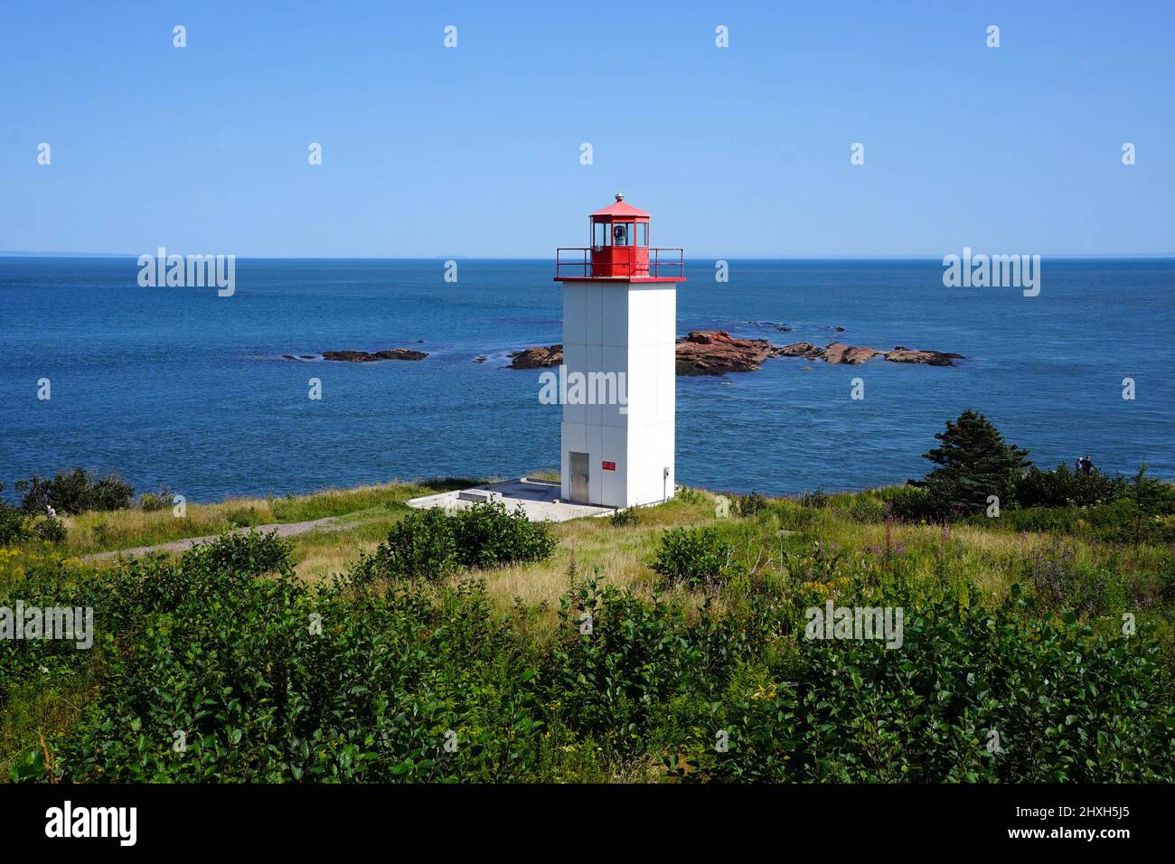 Lighthouse on a rocky shore at Quaco Head in New Brunwick's Bay of ...