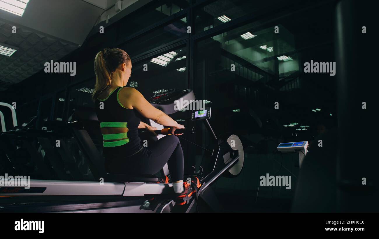 Fit Athletic Baby Woman Work out on Rowing Machine, Doing Her Fitness ...