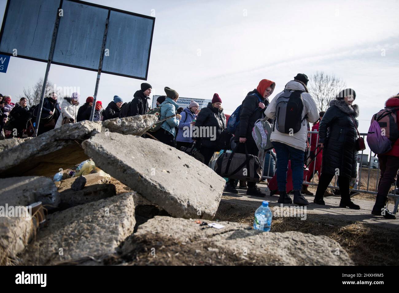 Ukrainian refugees are seen queuing to board a coach that takes ...