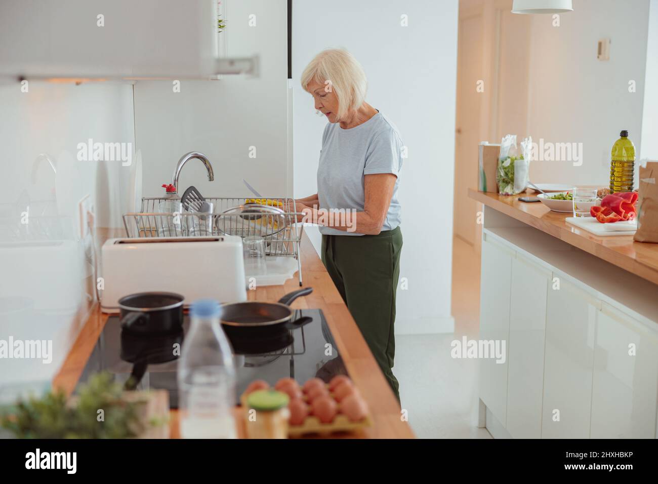 Woman elderly cleaning kitchen hi-res stock photography and images - Alamy