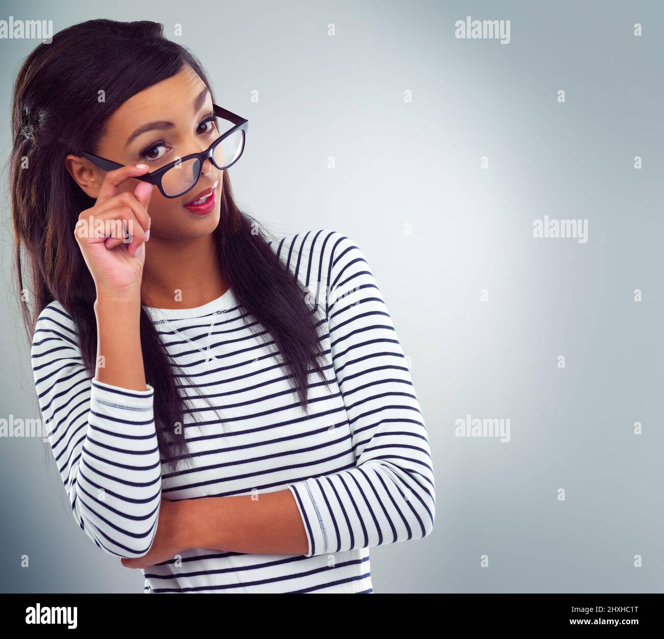Explain yourself. Shot of a young woman posing against a grey ...