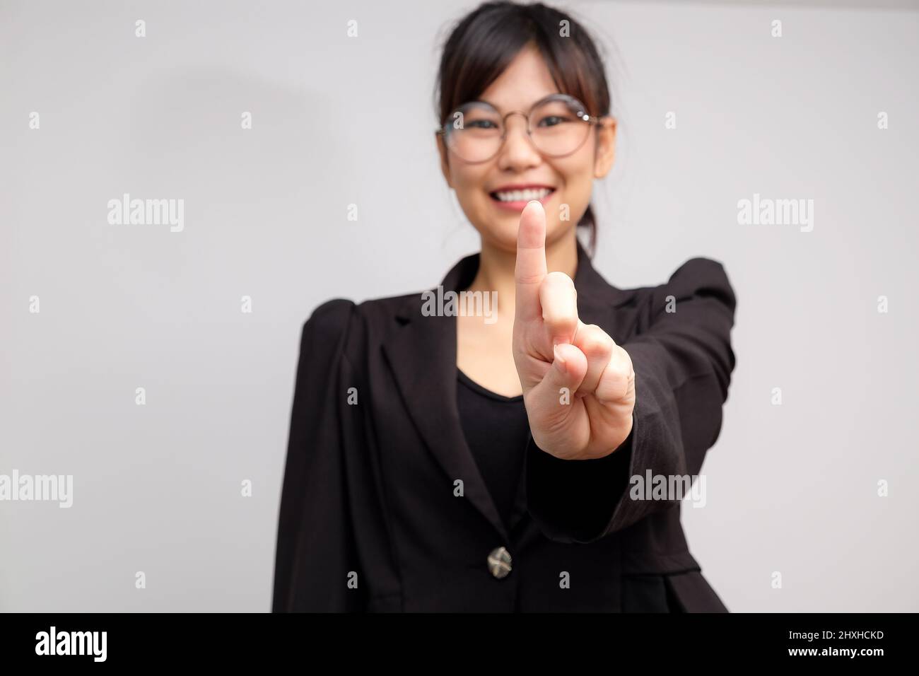 Smiling business asian women use hand show number one finger symbol on ...