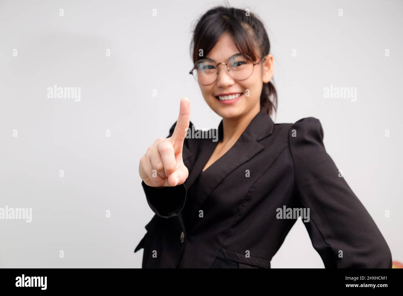 Smiling business asian women use hand show number one finger symbol on ...