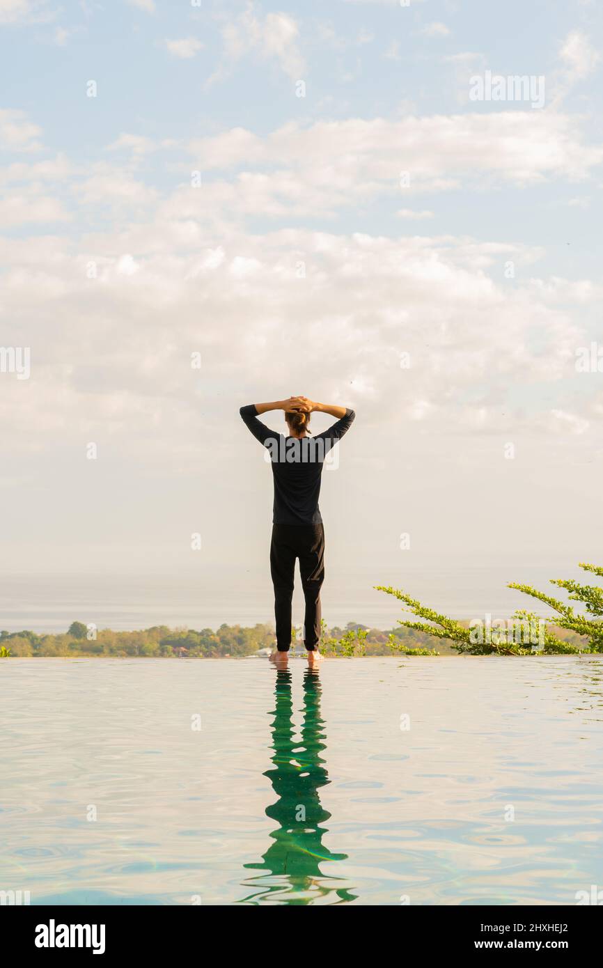 A man standing at the edge of infinity pool Stock Photo - Alamy