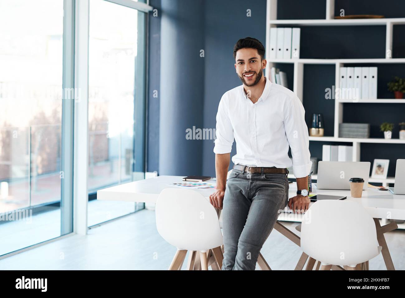 I make business happen here. Cropped portrait of a handsome young businessman sitting on his ...