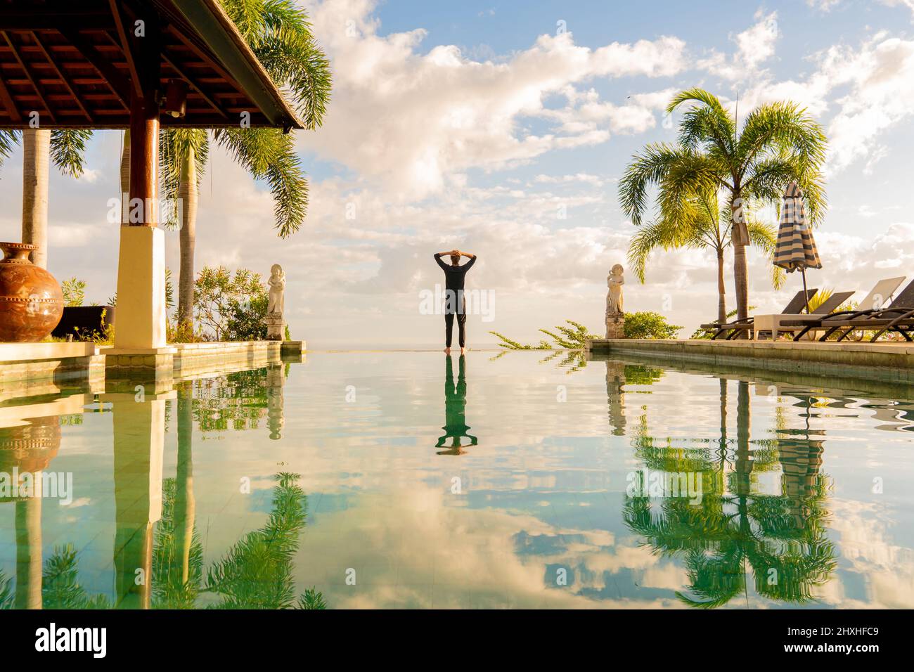 A man standing at the edge of infinity pool Stock Photo - Alamy