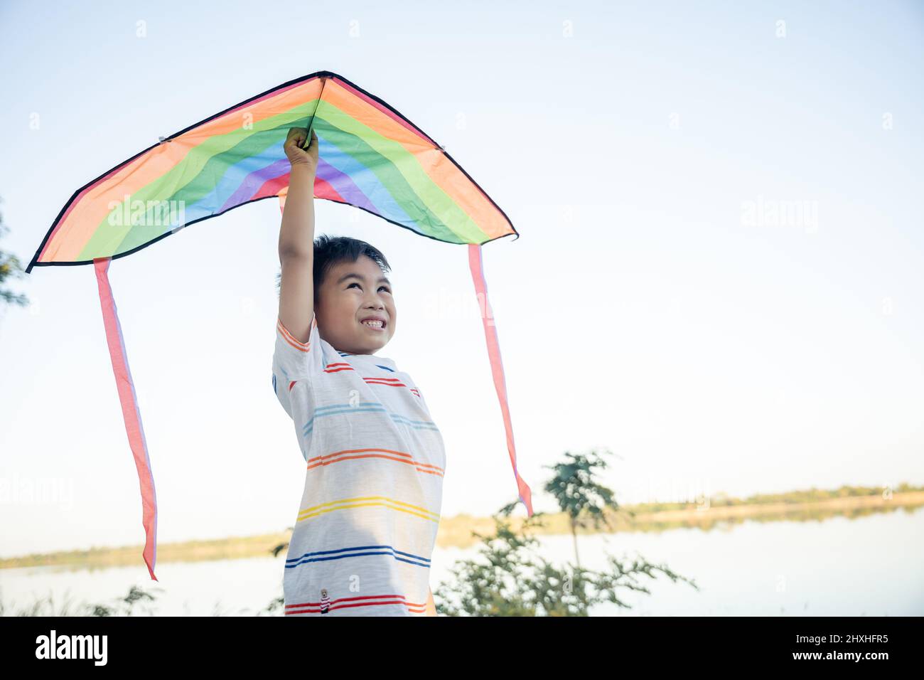 Asian happy children boy with a kite running to fly on in park at ...