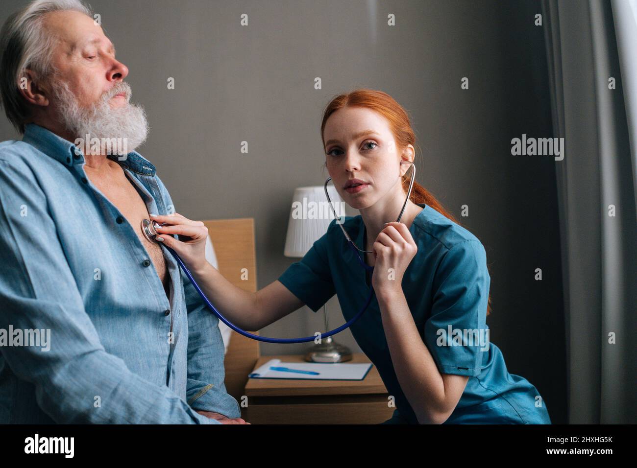 Side view of female doctor listening with stethoscope lungs and heart ...
