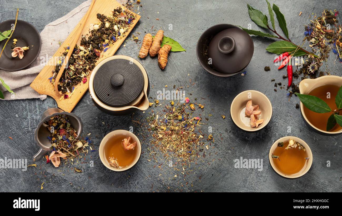 Asian tea set on dark background. Plant leaves, natural herbal tea ...