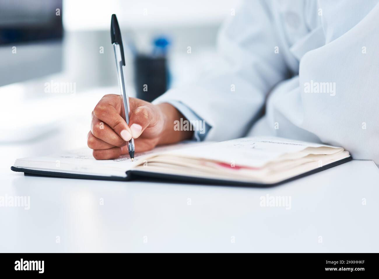 Noting down new findings. Closeup shot of an unrecognisable scientist ...