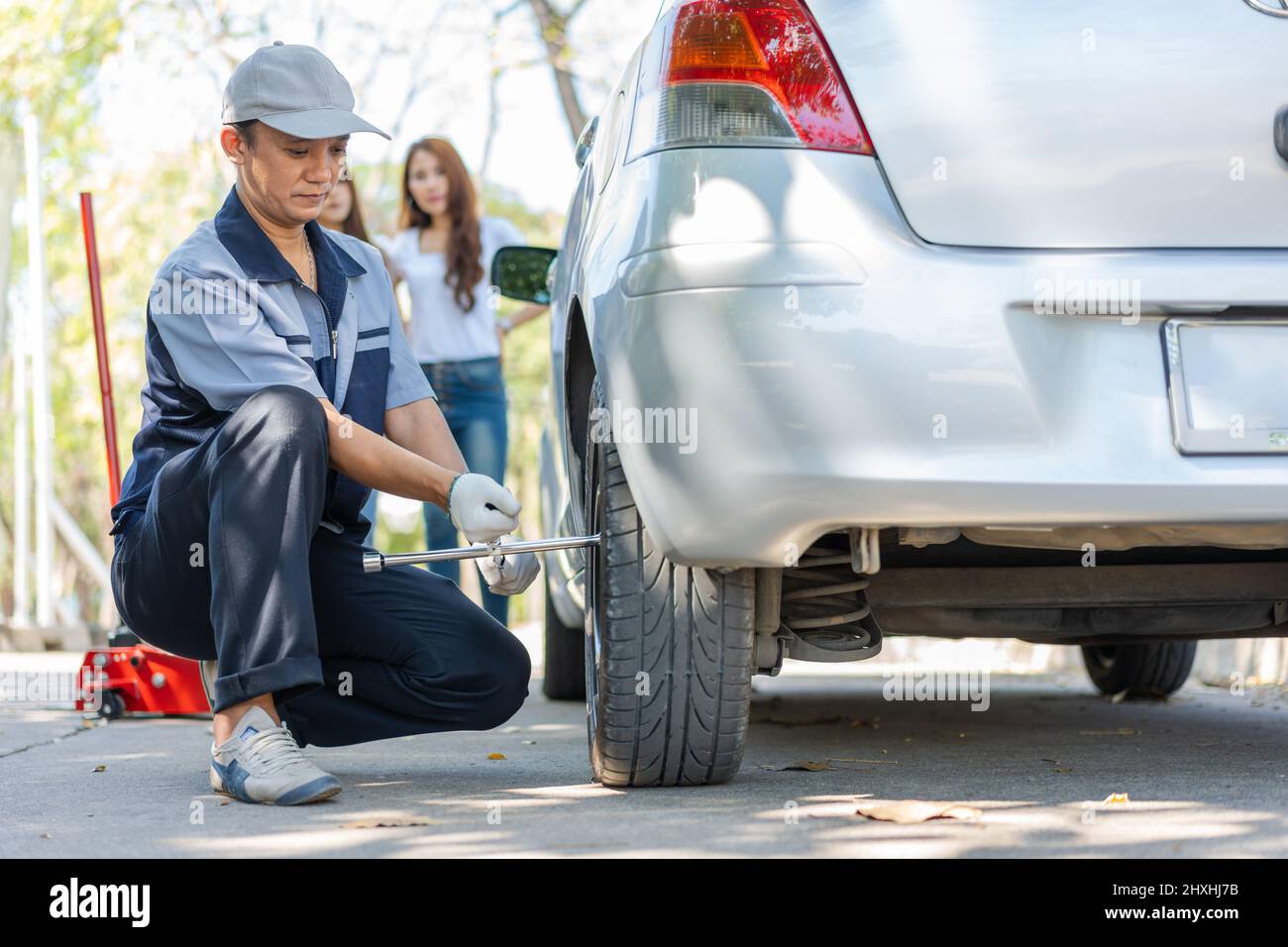 Expertise mechanic man in uniform using force trying to unscrew the ...