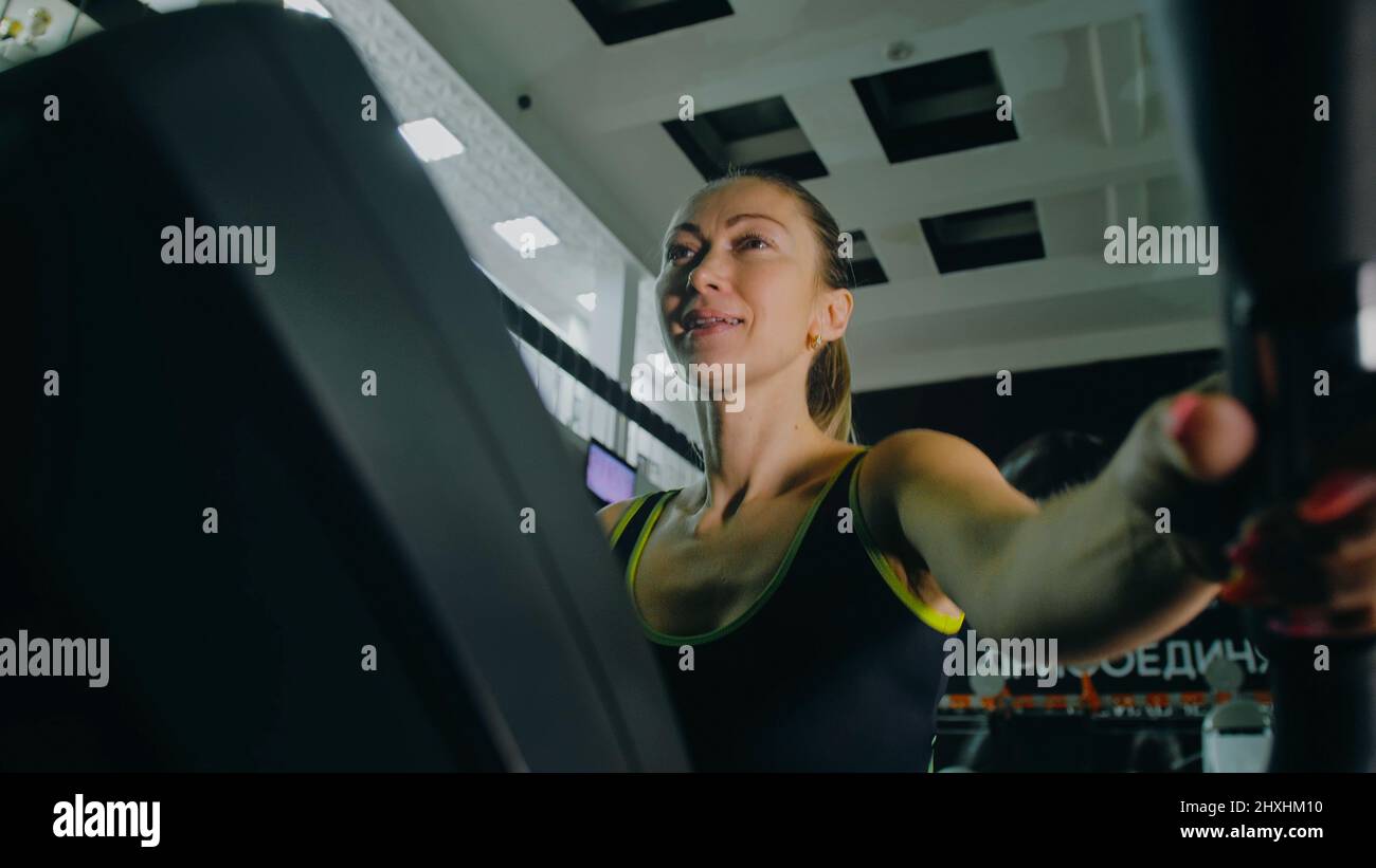 Fit Athletic Woman Exercising on an Elliptical Machine. Muscular Women ...