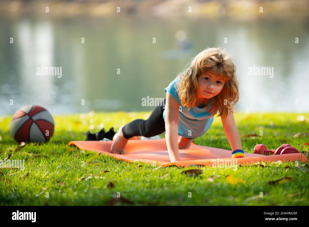Child boy is doing push up exercise in spring park. Healthy activities ...
