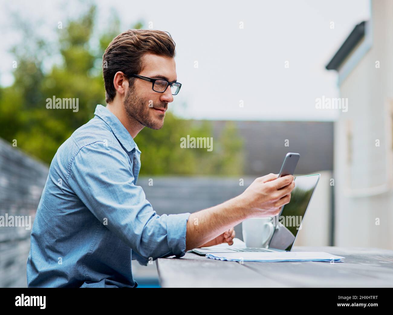 Keeping all his connections around. Shot of a handsome young man using ...