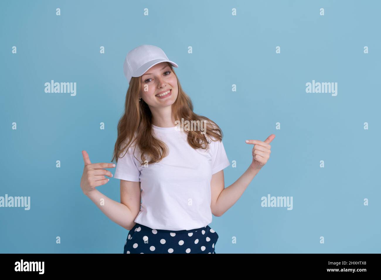 Confident cute woman pointing at herself. Young lady in white t-shirt ...