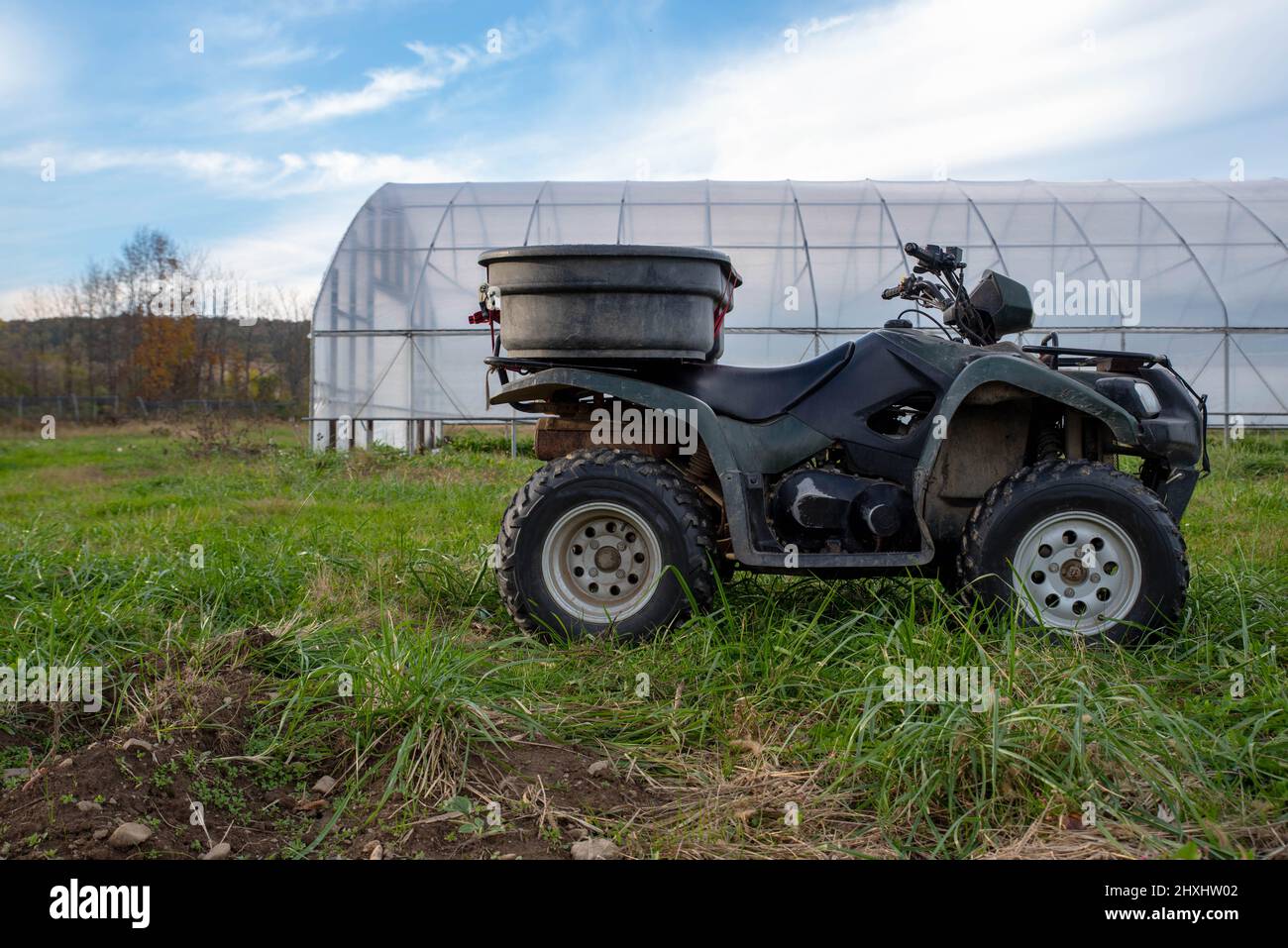 Side view of off road farm vehicle in green grass with greenhouse Stock ...