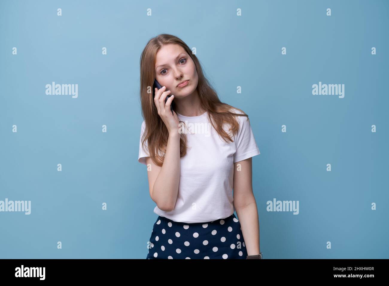 Excited young caucasian woman making or answering phone call, standing ...