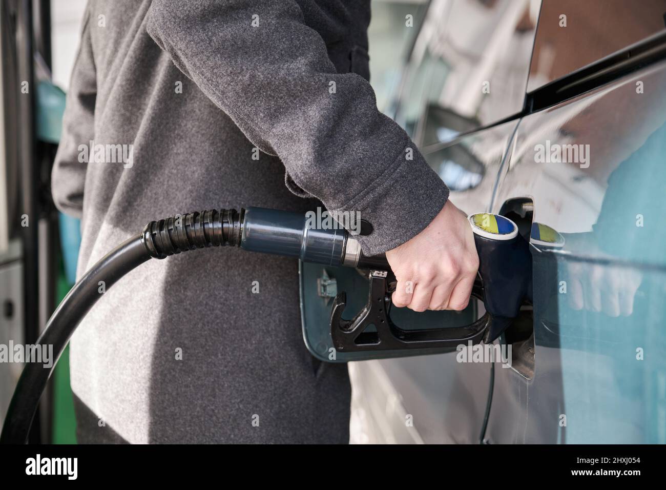 Unrecognizable man refilling his vehicle tank with diesel at a gas ...