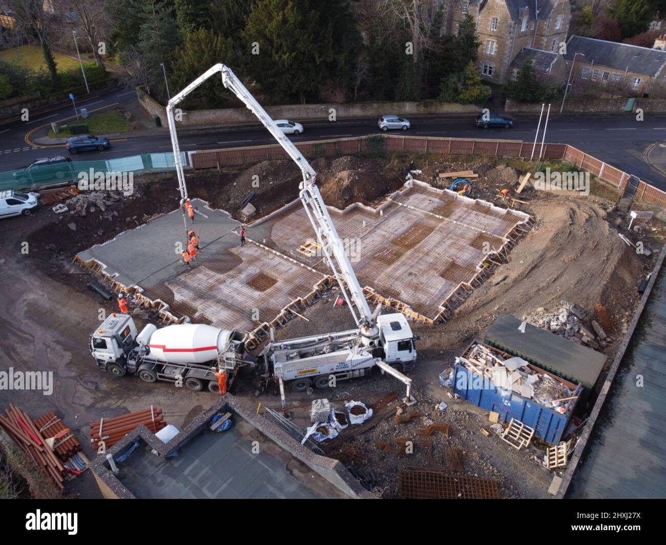 Workmen onsite at house construction, pouring base concrete layer from ...
