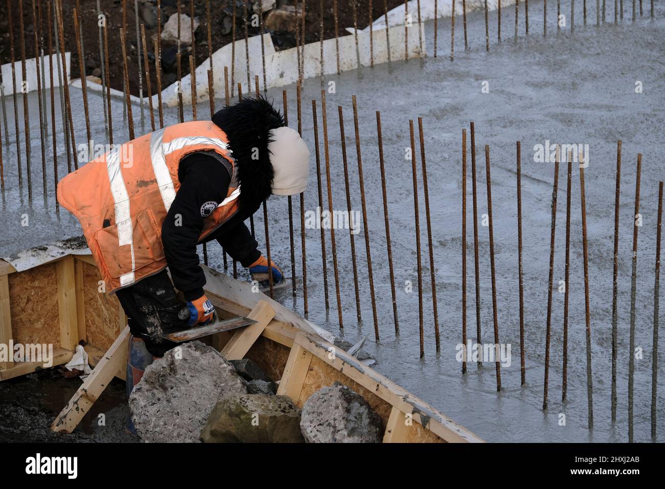 Workmen onsite at house construction, pouring base concrete layer from ...