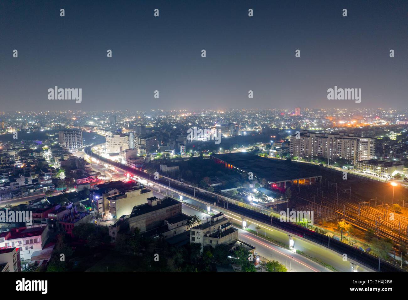 elevated metro track going across the screen over a lit road surrounded ...