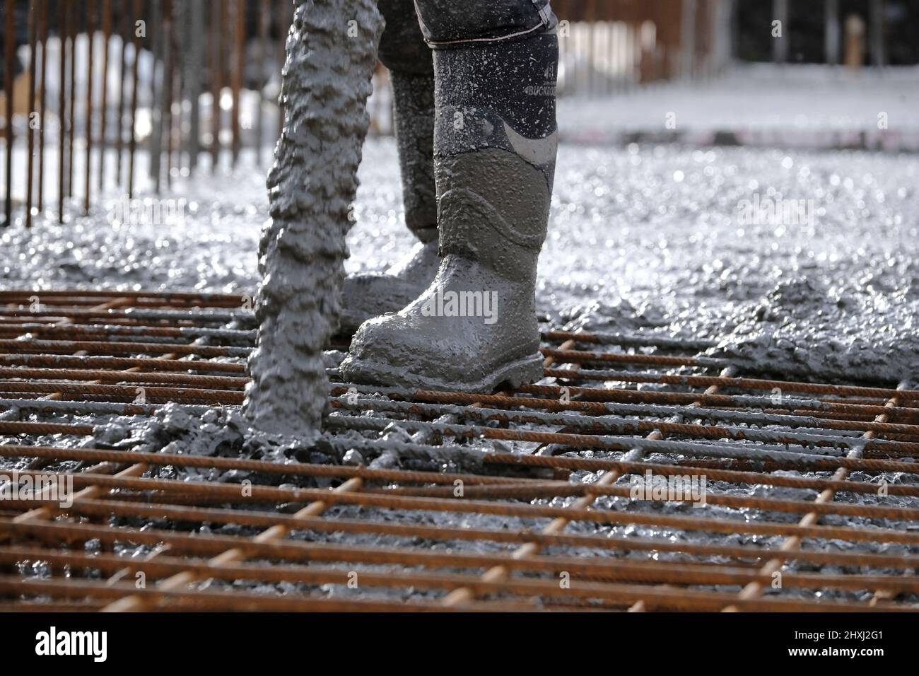 Workmen onsite at house construction, pouring base concrete layer from ...
