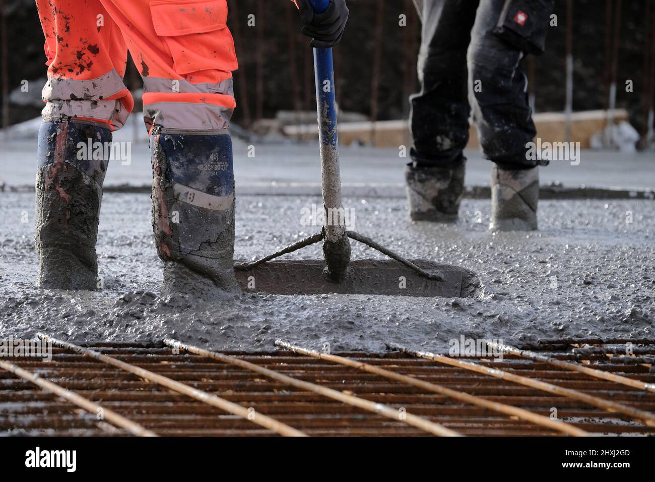 Workmen onsite at house construction, pouring base concrete layer from ...