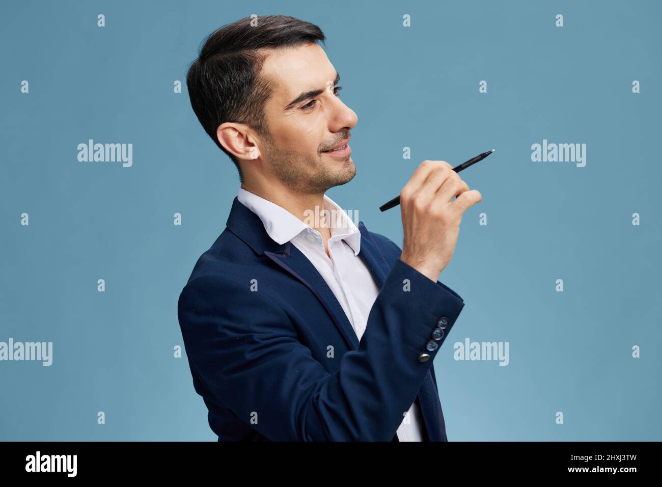 handsome man draws with a pen in the air close-up emotions isolated ...