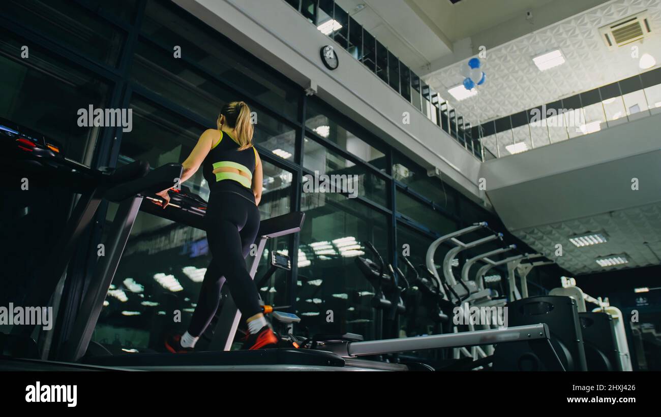 Fit Athletic Woman Running on the Treadmill, Doing Her Fitness Exercise ...