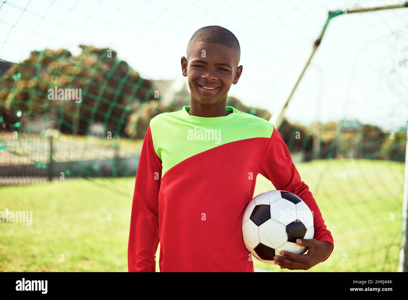 Wanna play some footy. Portrait of a young boy playing soccer on a ...